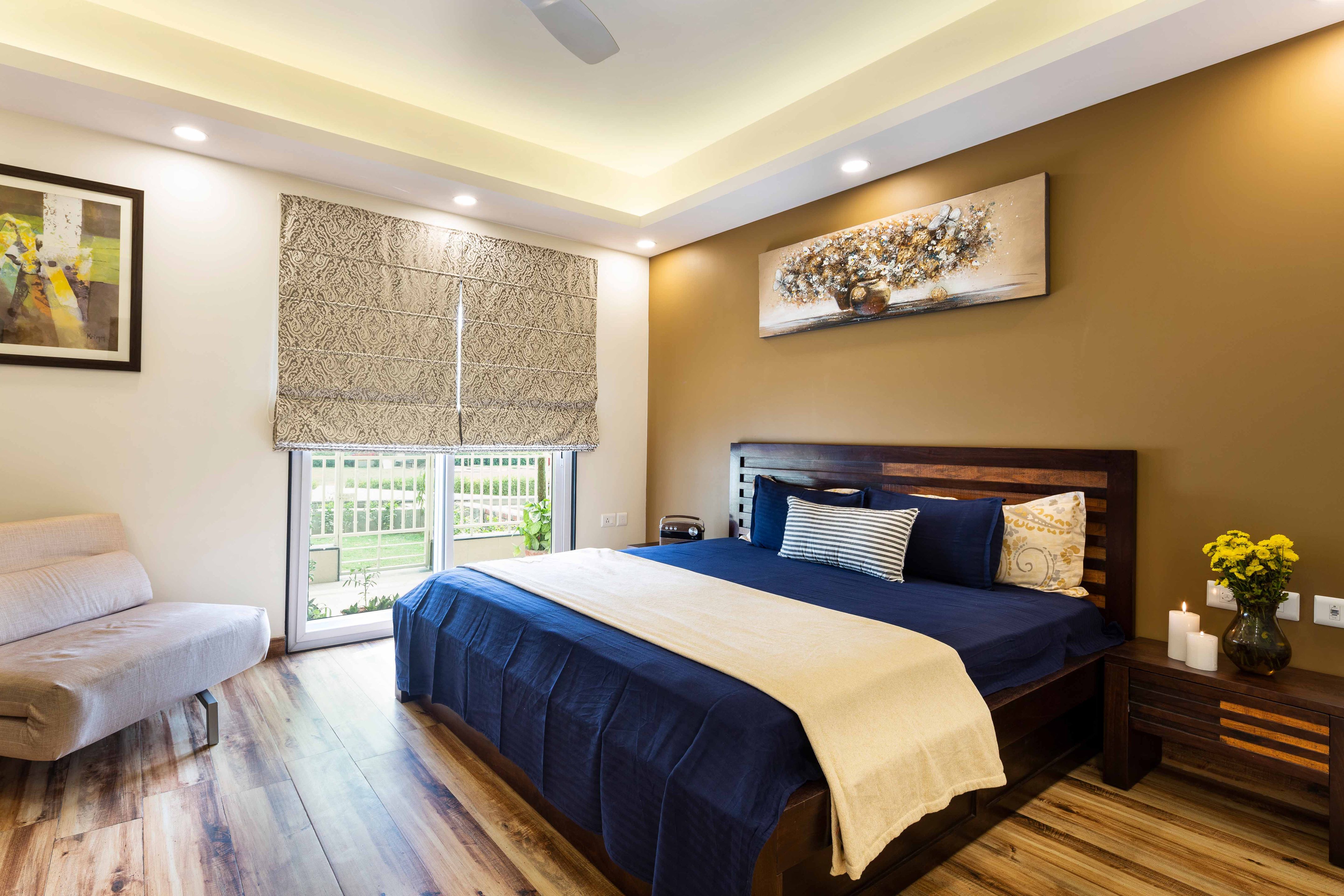 Spacious Guest Room Design With Tan Accent Wall And Wooden Flooring ...