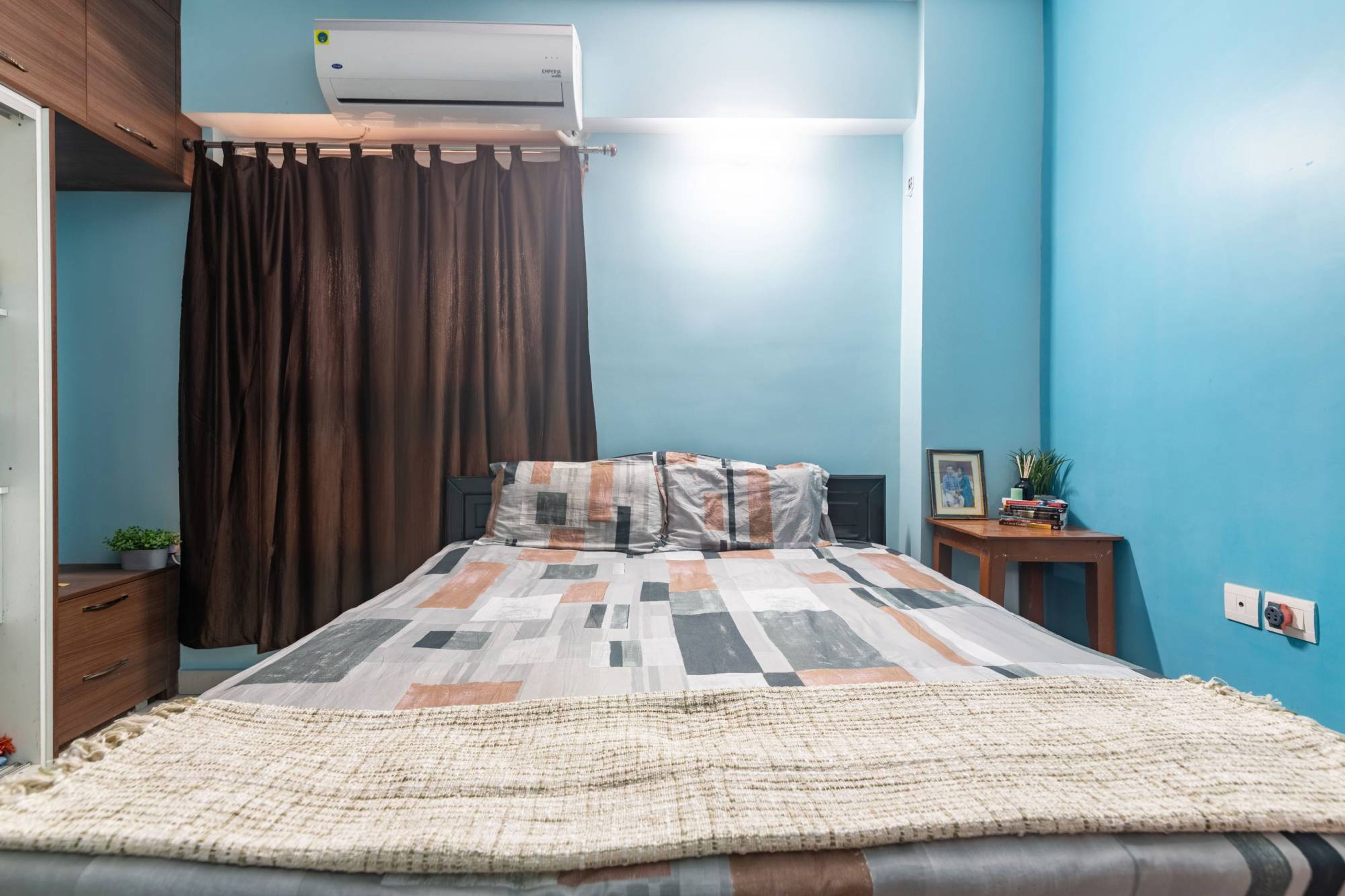 Spacious Guest Room Design With Blue Accent Wall | Livspace