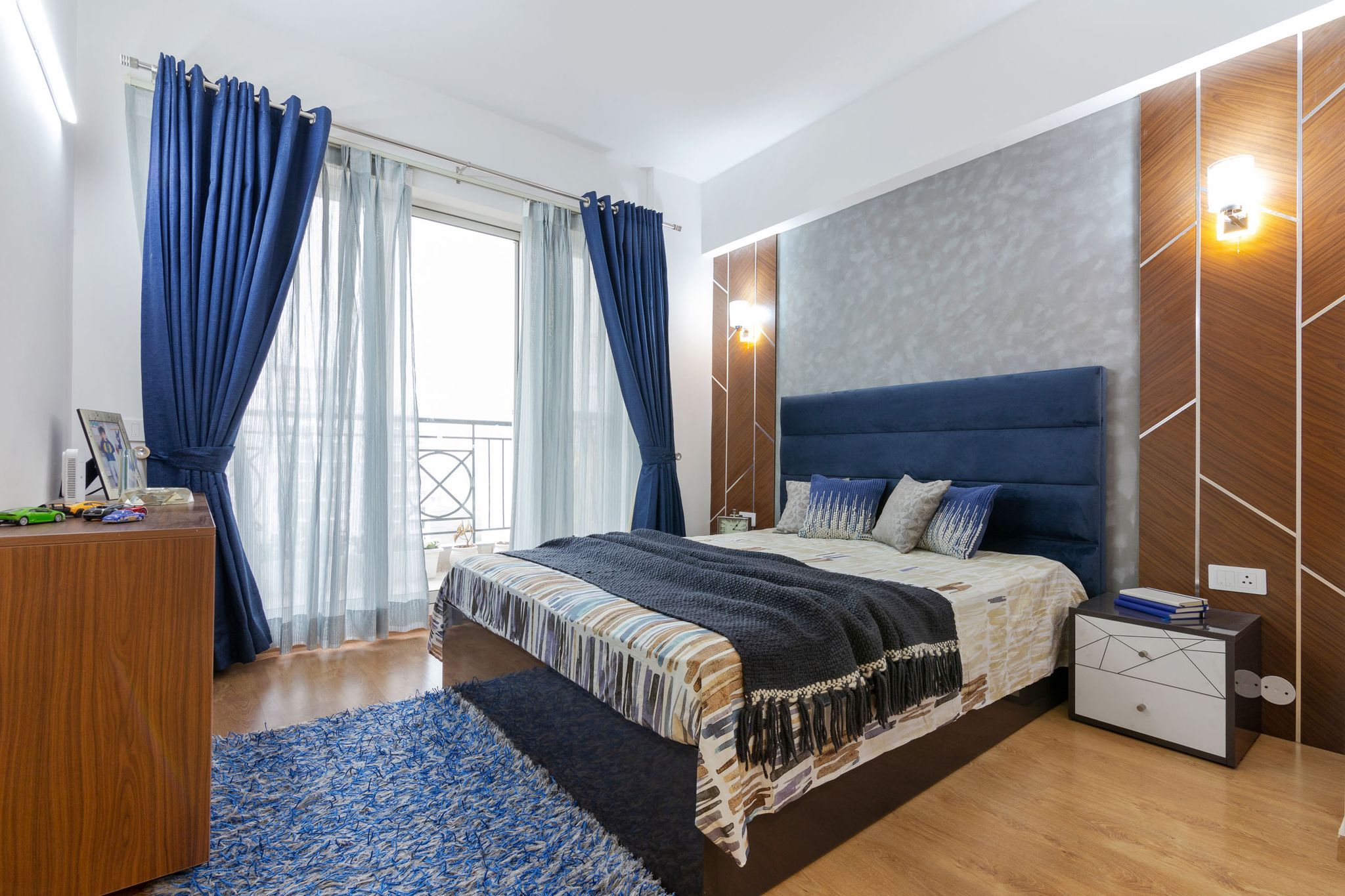 Contemporary Master Bedroom Design with Blue Panelled Headboard | Livspace